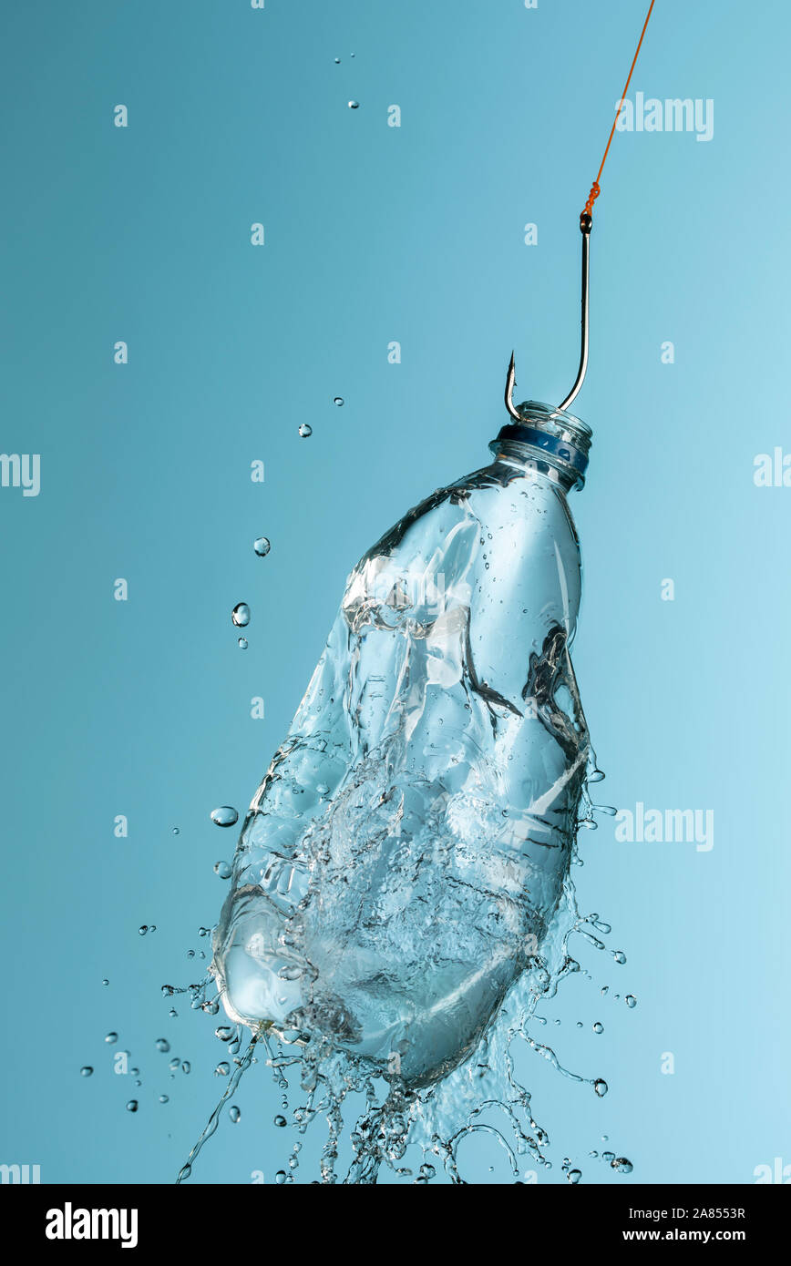 Hook pulling exploding plastic water bottle Stock Photo - Alamy