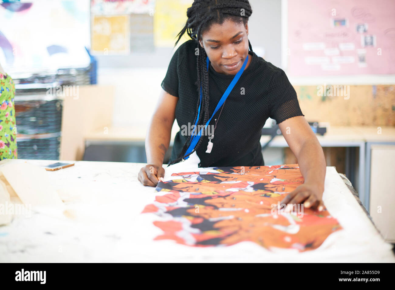 Female artist looking at screen print in studio Stock Photo - Alamy