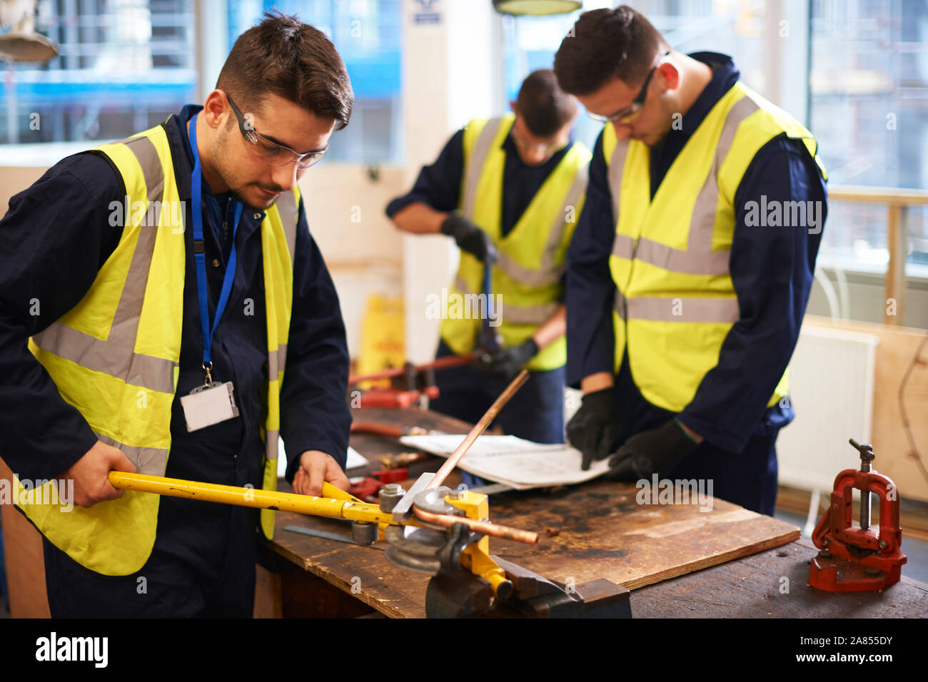 Male students using equipment in shop class workshop Stock Photo - Alamy