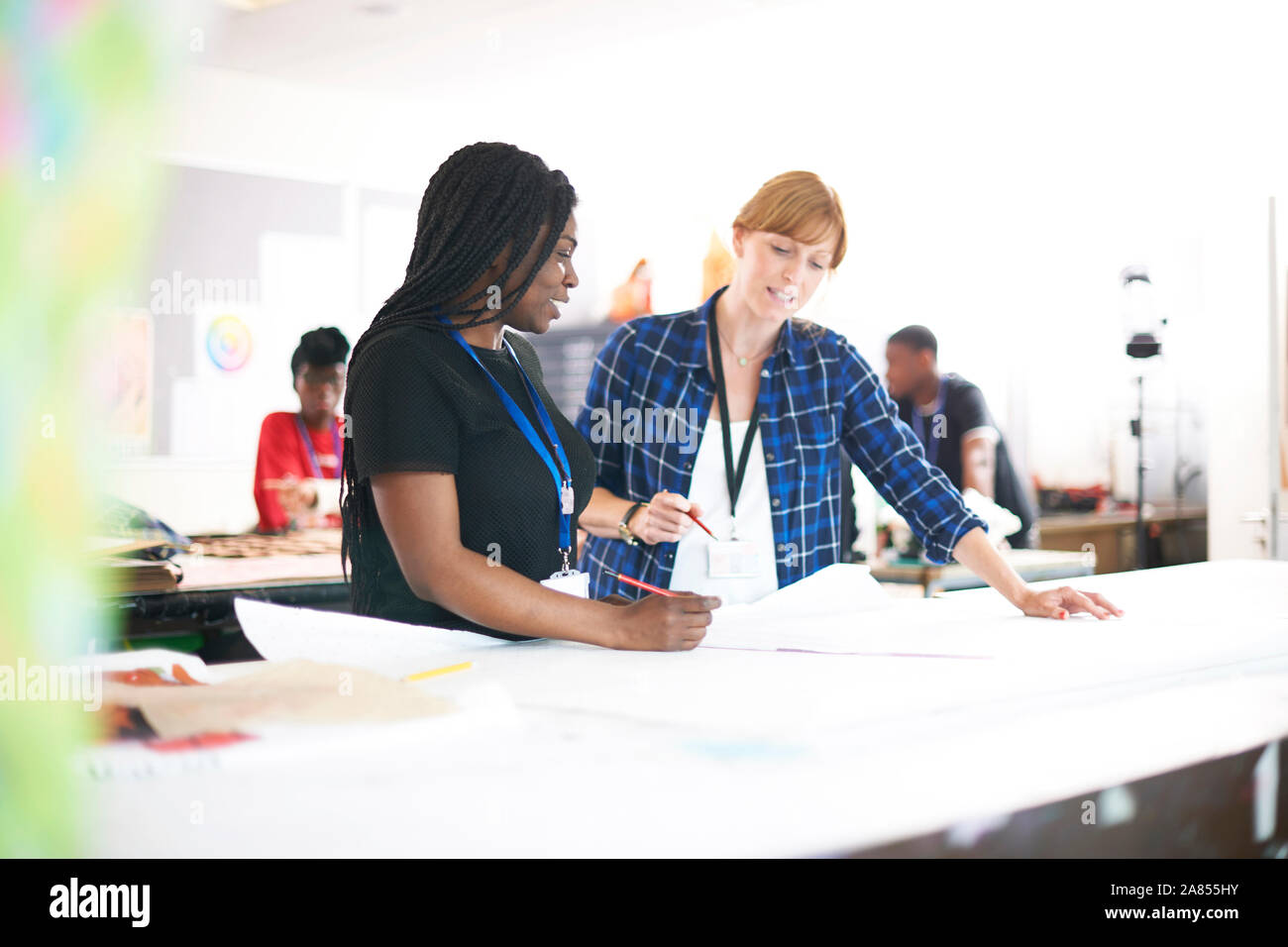 Female fashion designers drawing sewing pattern in studio Stock Photo ...