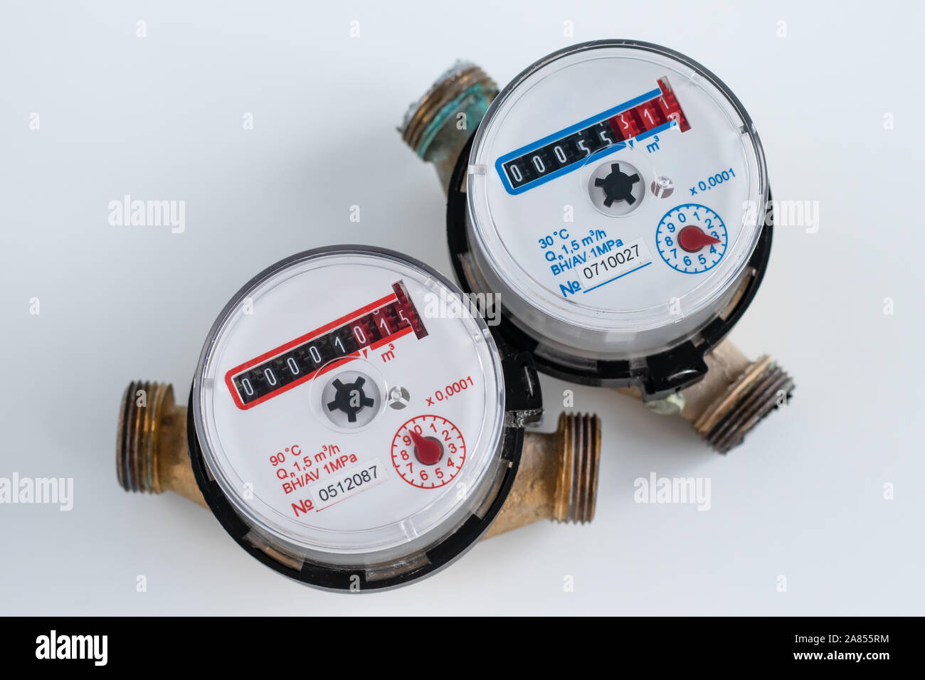 A two residential water meters on white background. A used up ...
