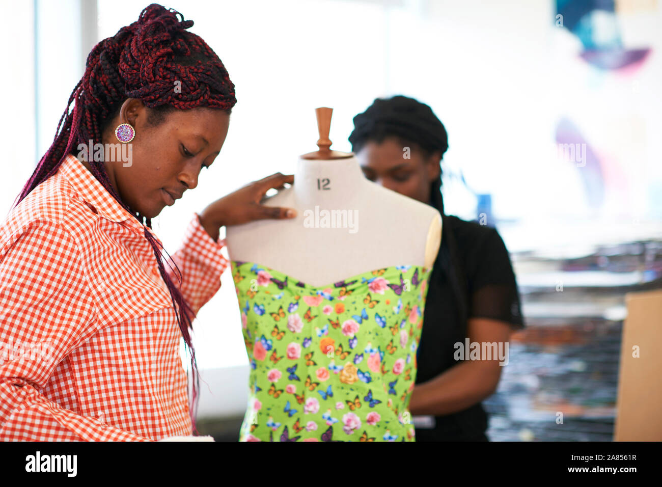 Female fashion designers using dressmakers model Stock Photo - Alamy