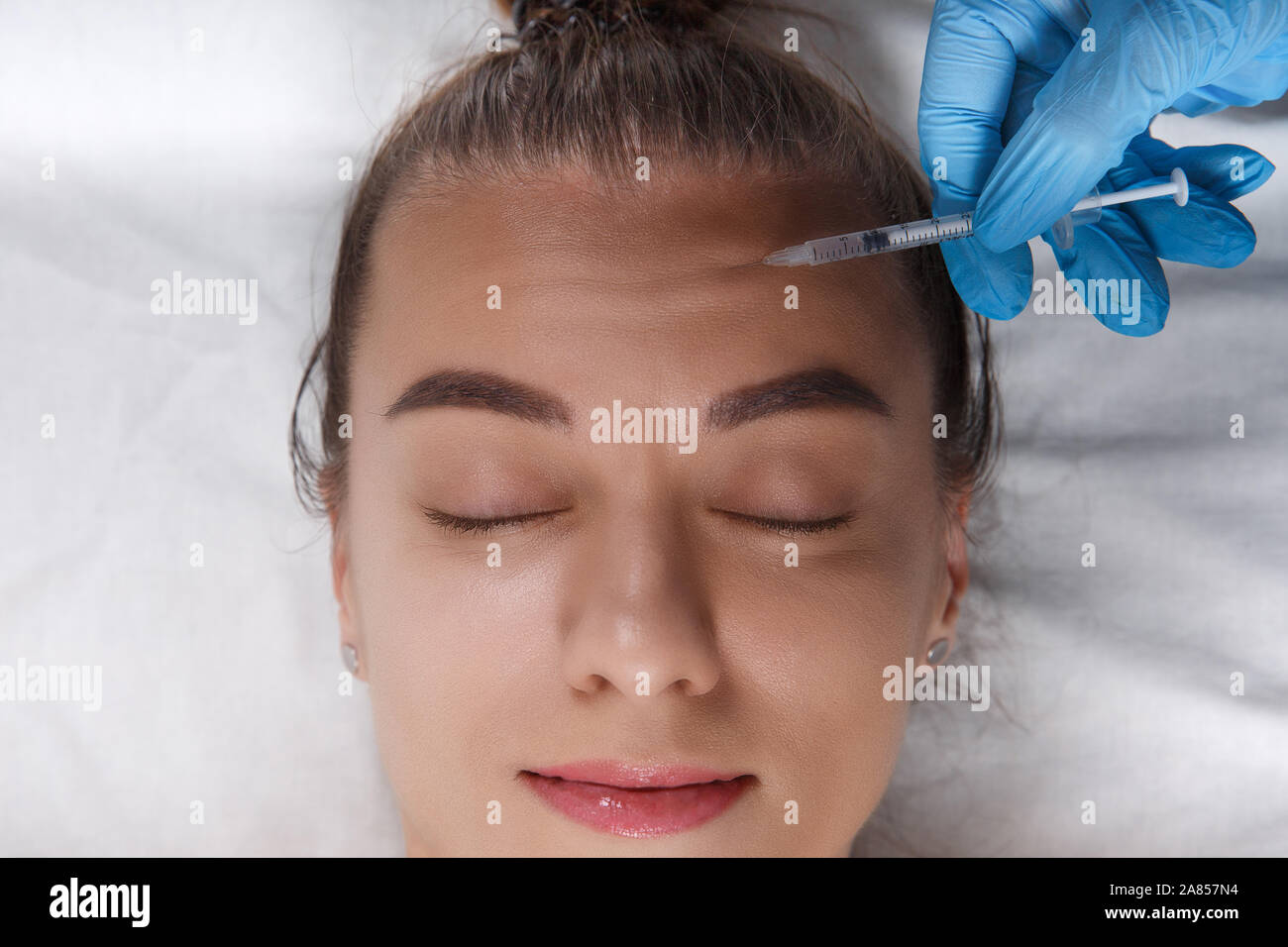 Closeup Portrait of young Caucasian woman getting cosmetic injection in ...
