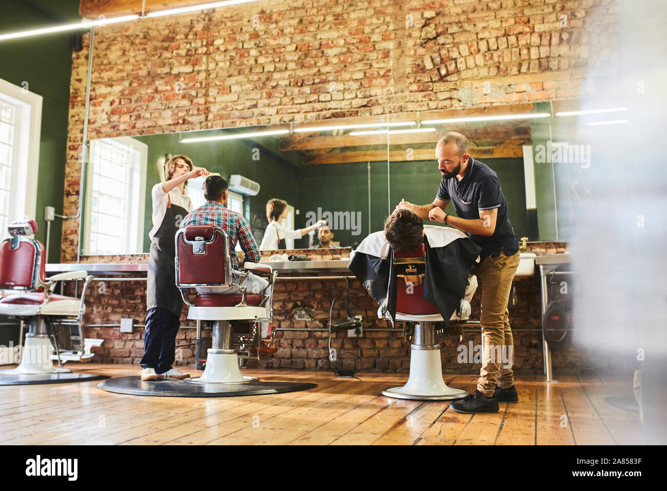 Male barbers and customers in barbershop Stock Photo - Alamy