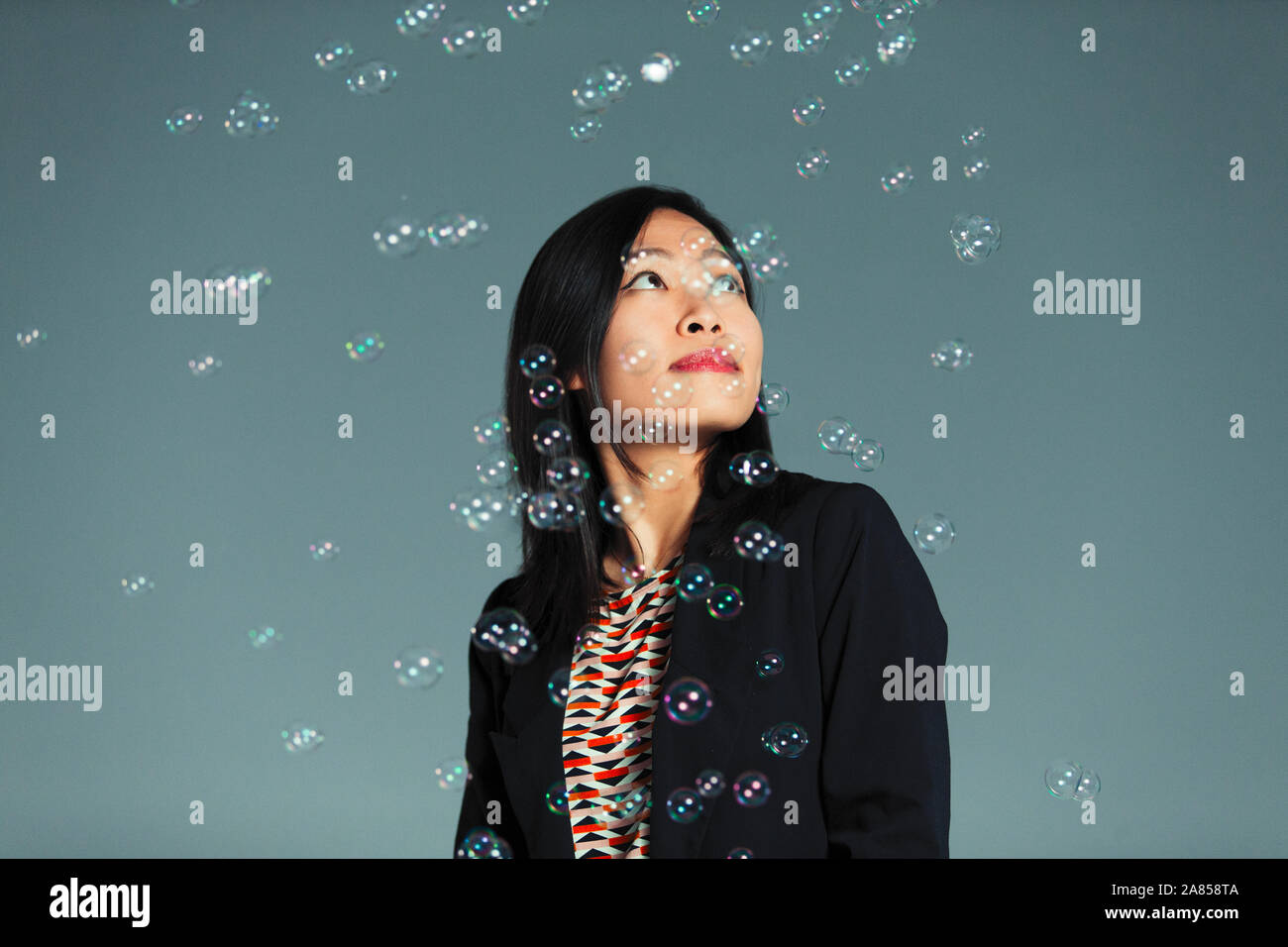Bubbles falling around curious woman Stock Photo - Alamy