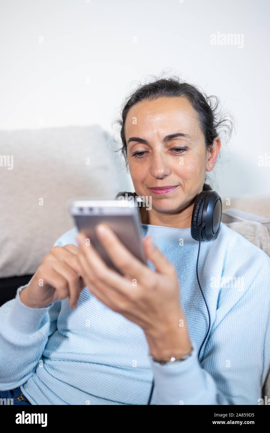 Pretty young spanish woman with smart phone at home Stock Photo - Alamy
