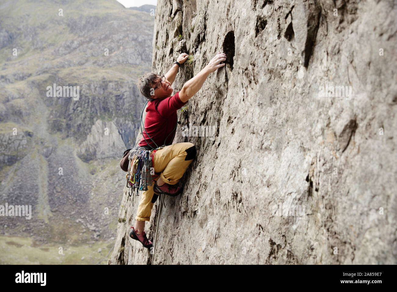 Focused male rock climber scaling rock face Stock Photo - Alamy