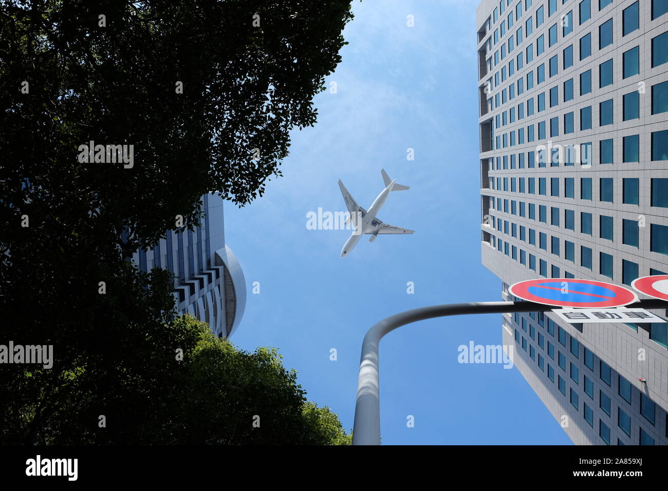 A commercial flight flying over the buildings in Osaka Stock Photo - Alamy