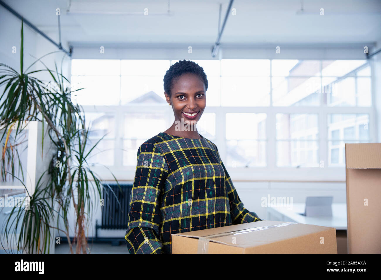 Portrait confident businesswoman moving into new office Stock Photo - Alamy