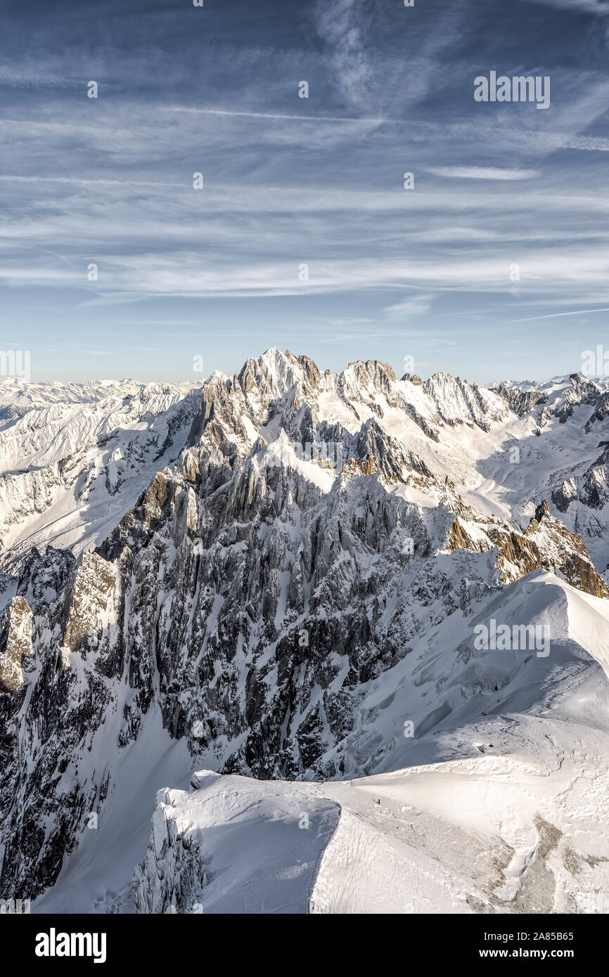 Skier hiker slowy walk down on a massive snow mountain slope on top of ...