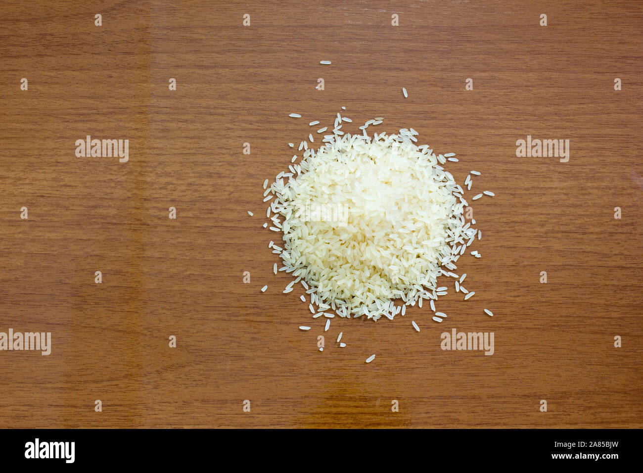 White rice spreads on the brown table Stock Photo - Alamy