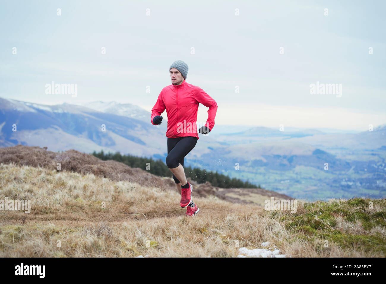 Man jogging on remote mountain trail Stock Photo - Alamy