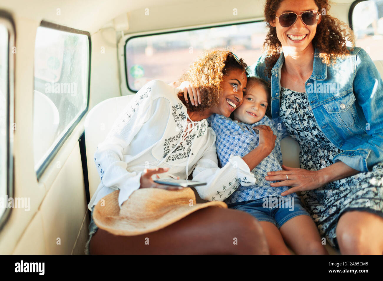 Happy women and girl riding in van Stock Photo - Alamy