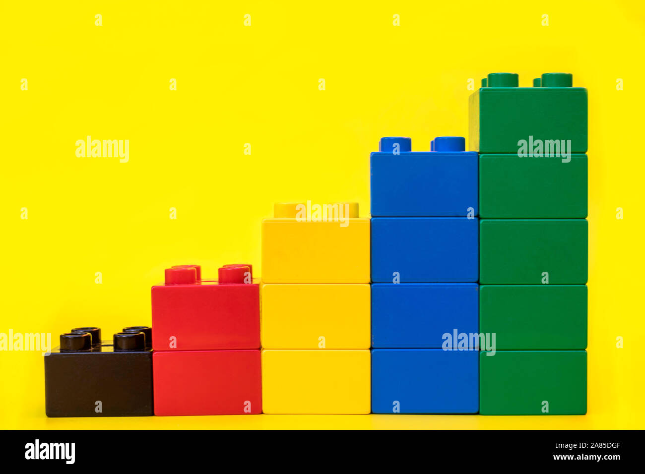 Bar graphs plastic building blocks toy bricks on yellow background ...