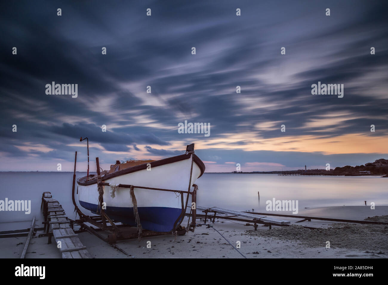 Fishing boat on the beach at sunset Stock Photo - Alamy