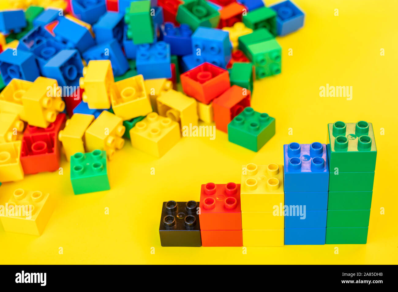 Bar graphs plastic building blocks toy bricks on yellow background ...