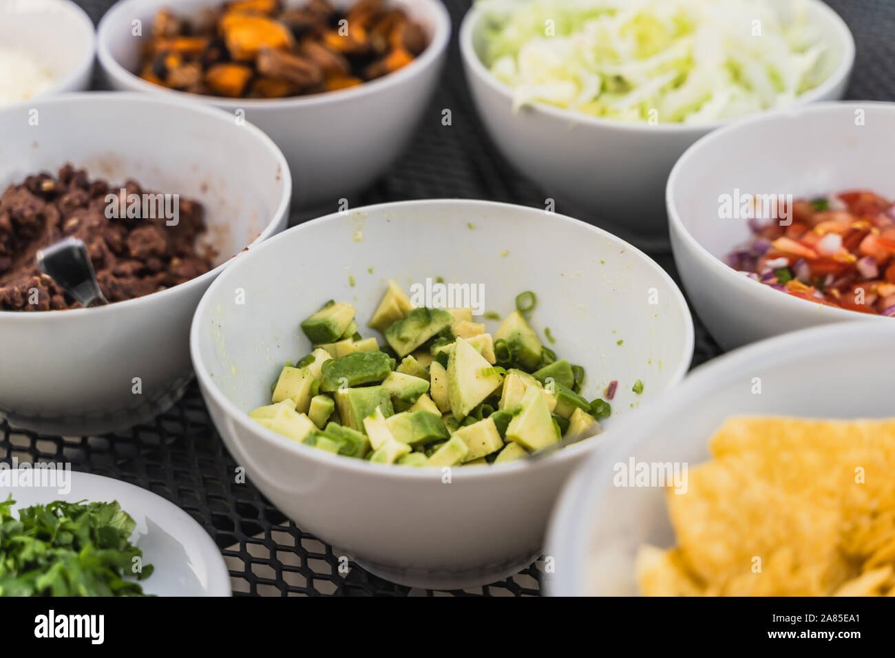 Tortilla dipping into smashed avocado, green guacamole dip Stock Photo ...