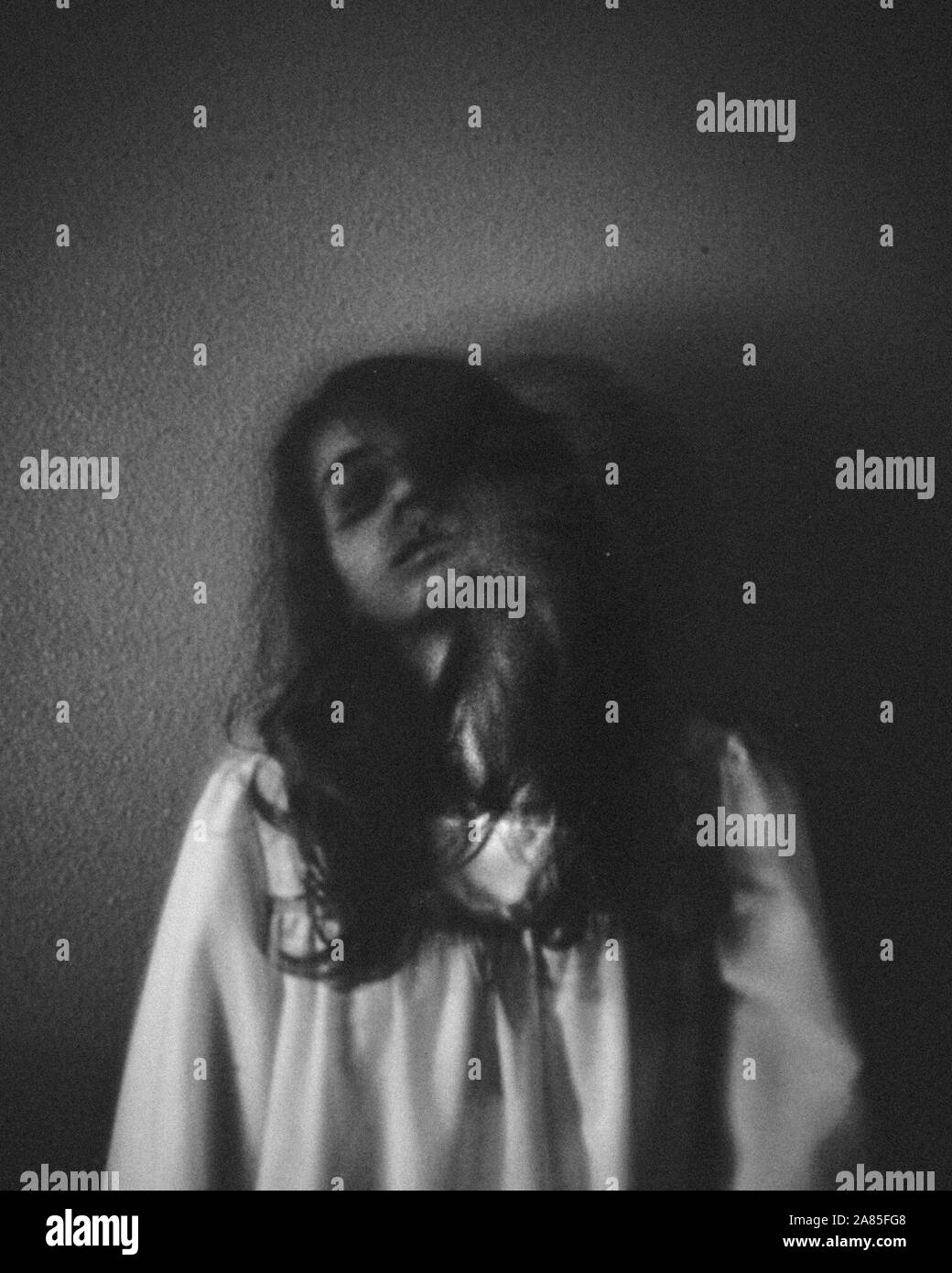 Spooky portrait of ghost girl standing against wall Stock Photo - Alamy