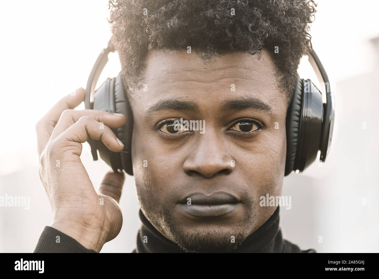 portrait of a serious african black man listening music with a hand ...