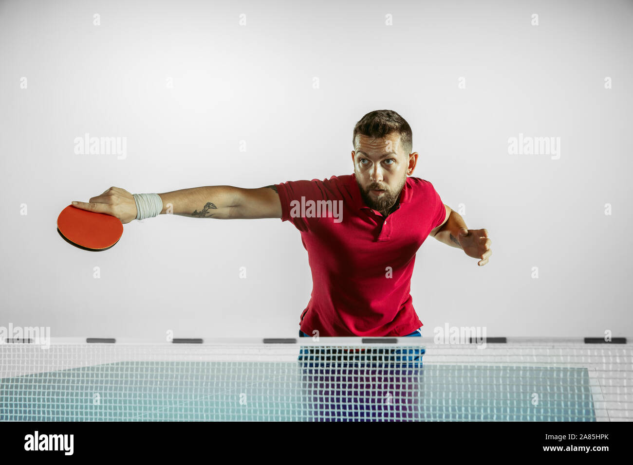 Start. Young man plays table tennis on white studio background. Model ...
