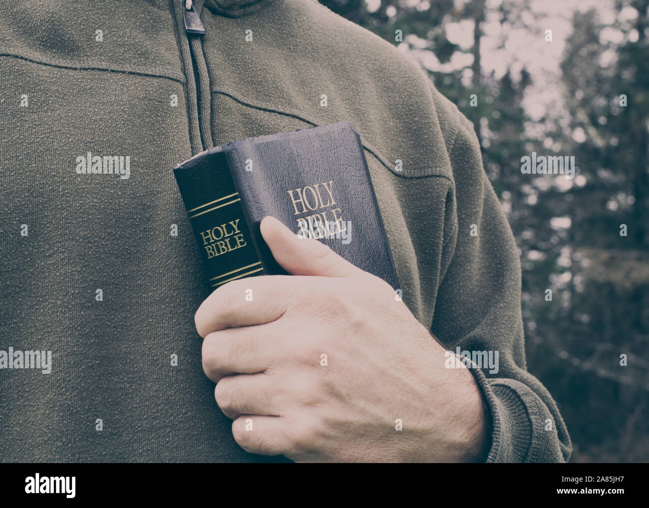 Man carrying Holy Bible. Faded look Stock Photo - Alamy