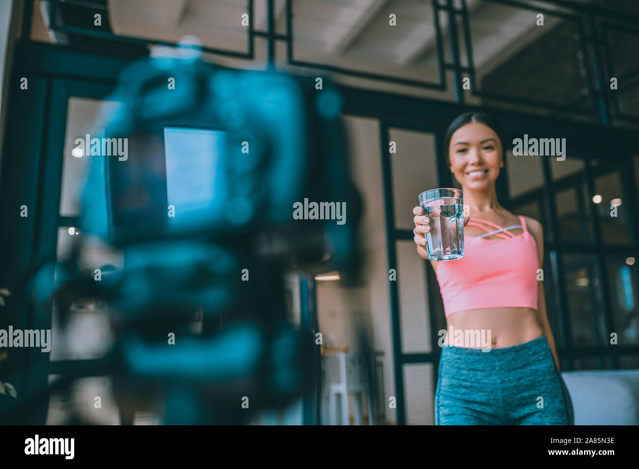 Young fitness trainer drinking water before exercising Stock Photo - Alamy