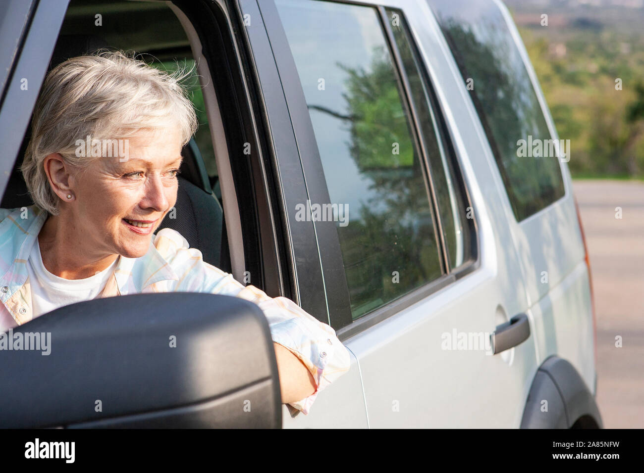 Senior woman driving a Land Rover Stock Photo - Alamy