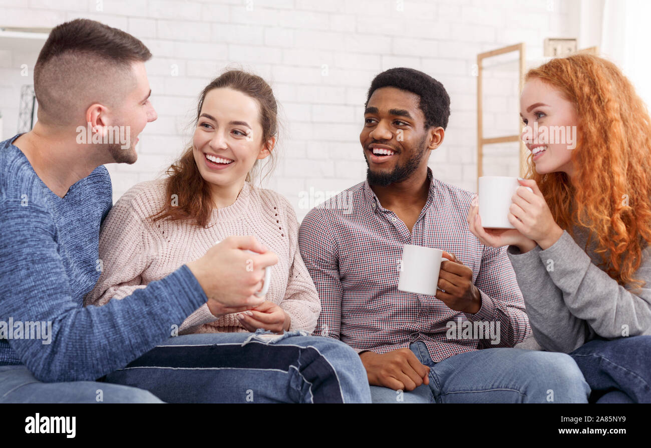Joyful friends drinking tea and talking at home Stock Photo - Alamy