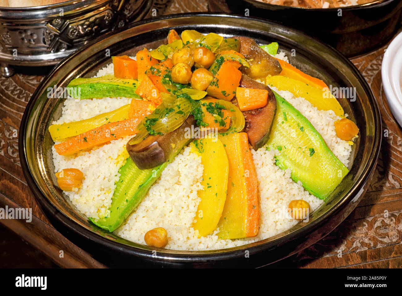 Moroccan couscous tajin on carved, wooden table Stock Photo - Alamy