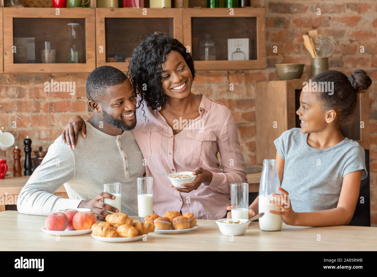 Adorable black family of three having breakfast at kitchen Stock Photo ...