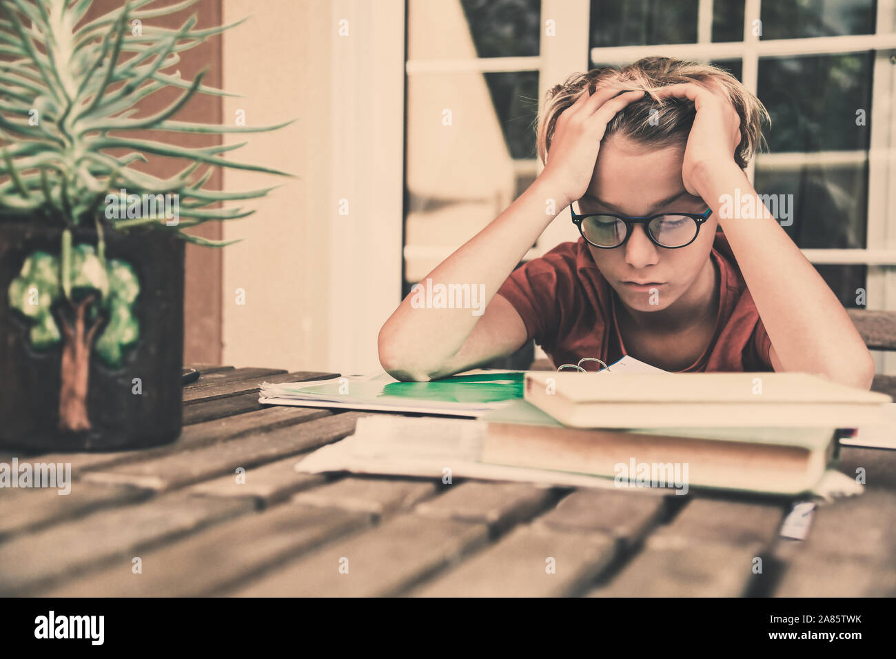 Tired student doing homework at home sitting outdoor with school books ...