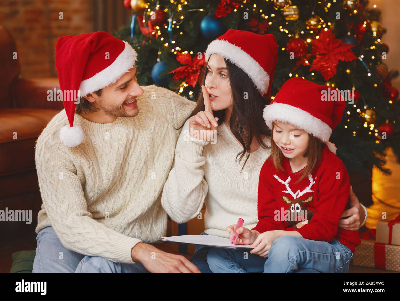 Young beautiful family writing letter to Santa together Stock Photo - Alamy