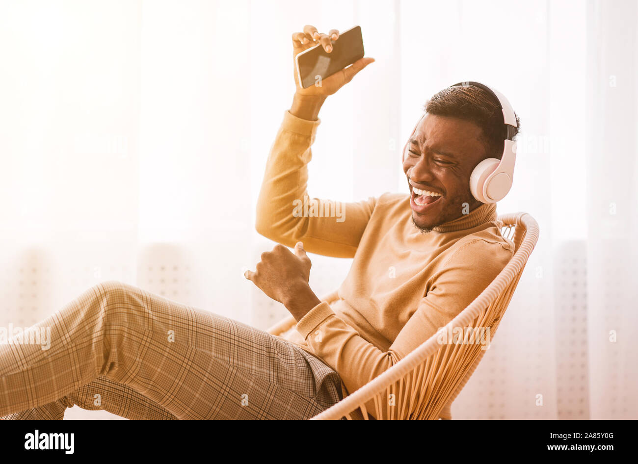 Man In Headphones Using Phone Listening Songs Sitting Indoor Stock ...