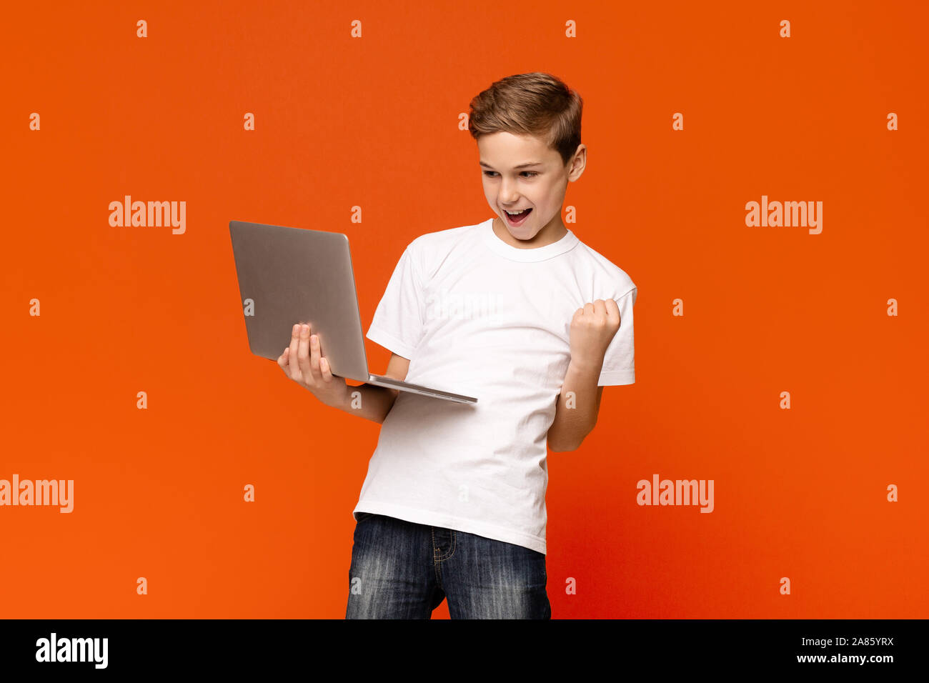 Excited teen boy using laptop computer, celebrating success Stock Photo ...
