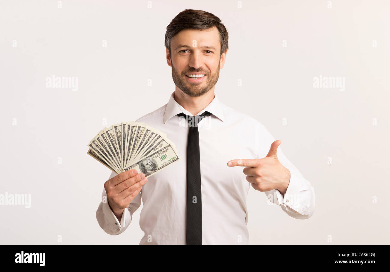 Smiling man pointing dollars hi-res stock photography and images - Alamy