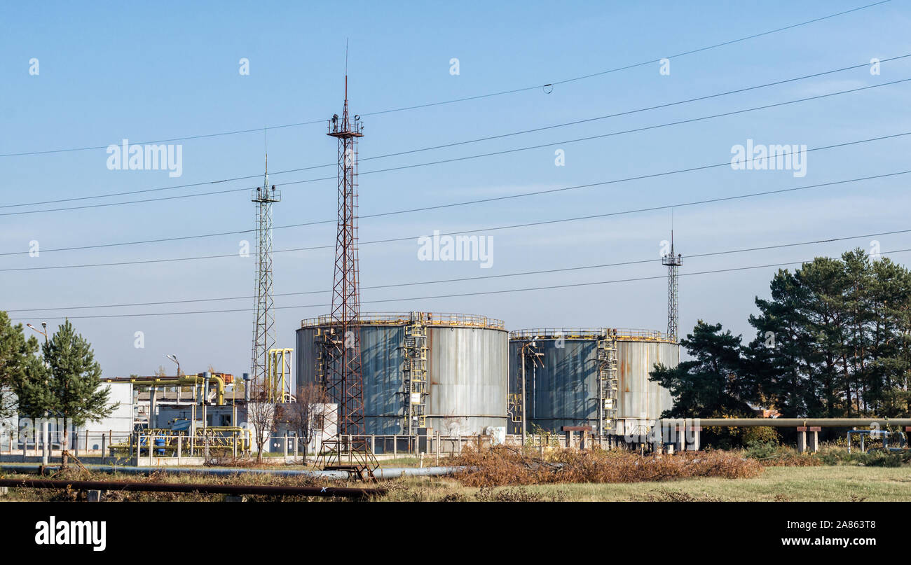 storage tanks of nuclear waste among green trees against a blue sky in ...