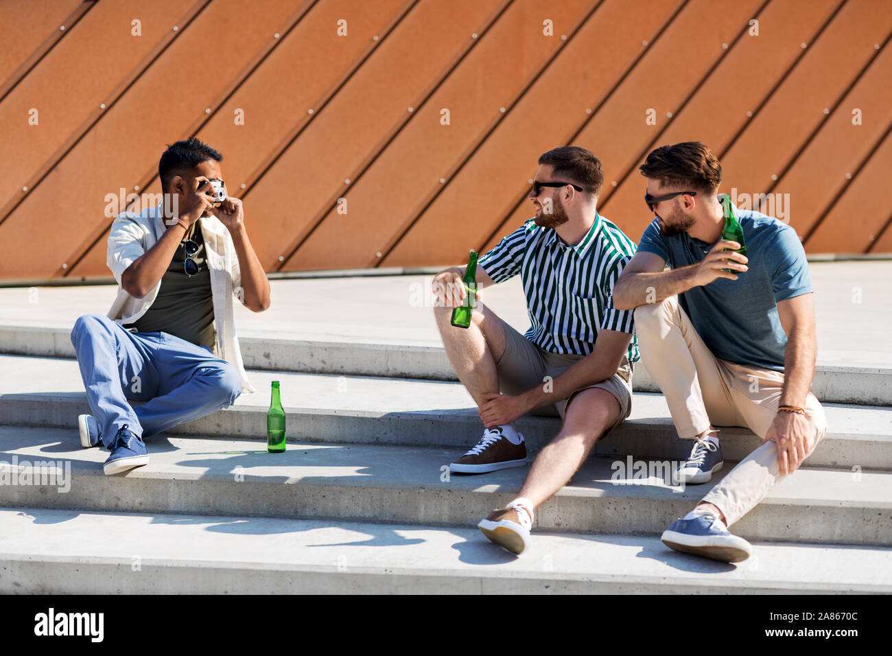man photographing friends drinking beer on street Stock Photo - Alamy