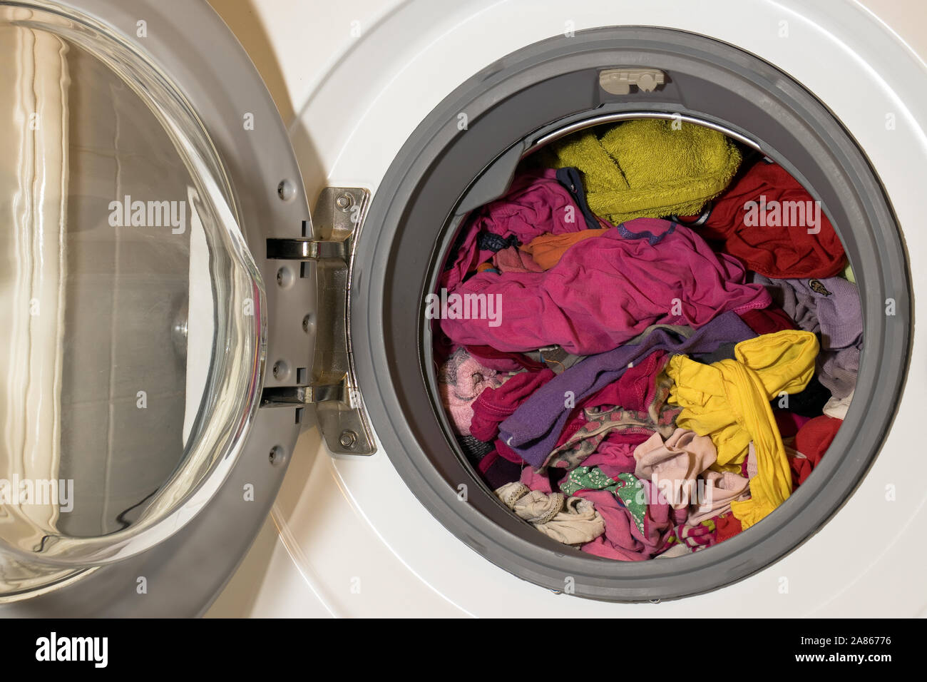 Colorful clothes in opened washing machine prepared for washing Stock ...