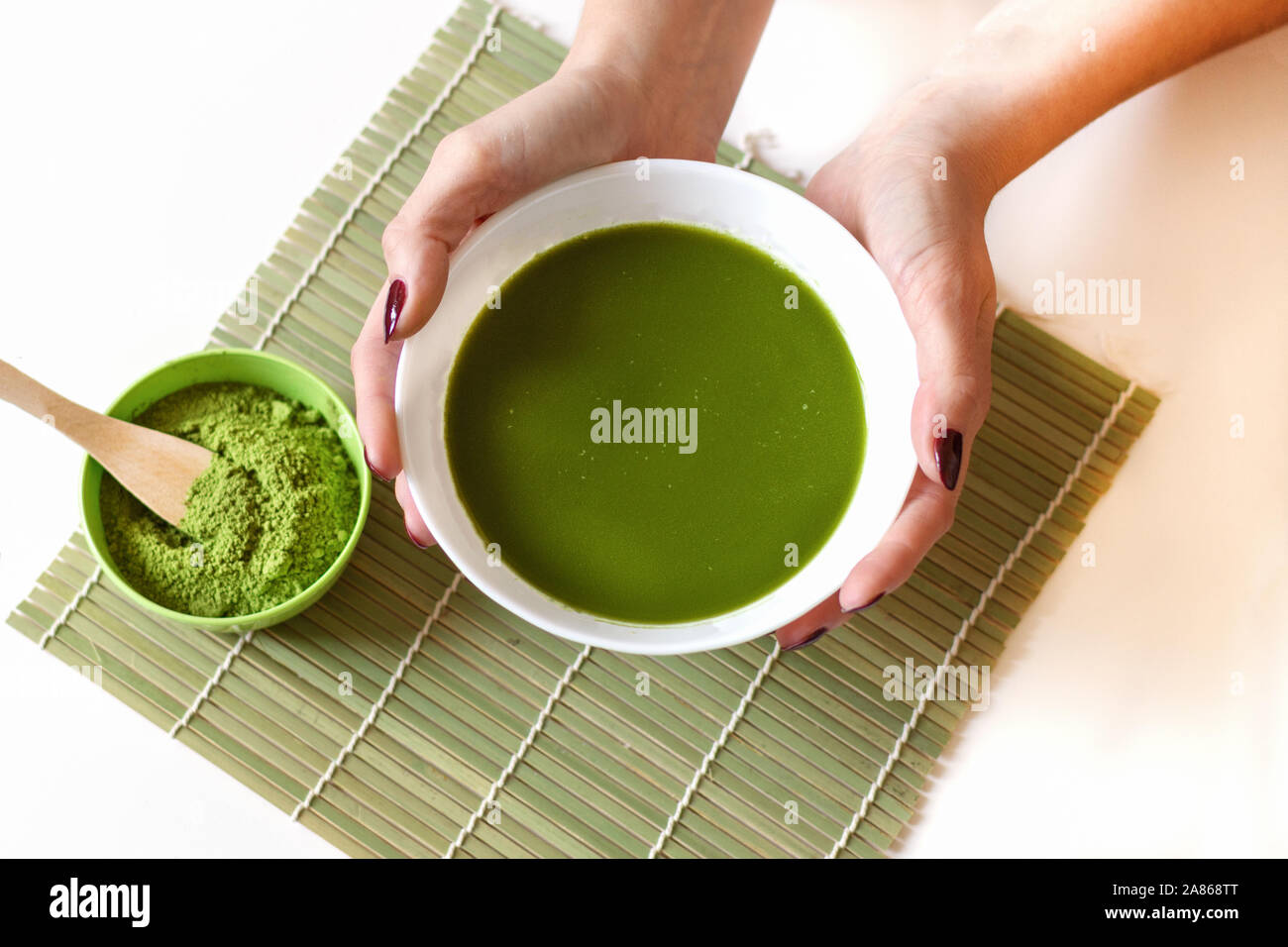 Wooden spoon with powdered matcha green tea in bowl, isolated on white ...