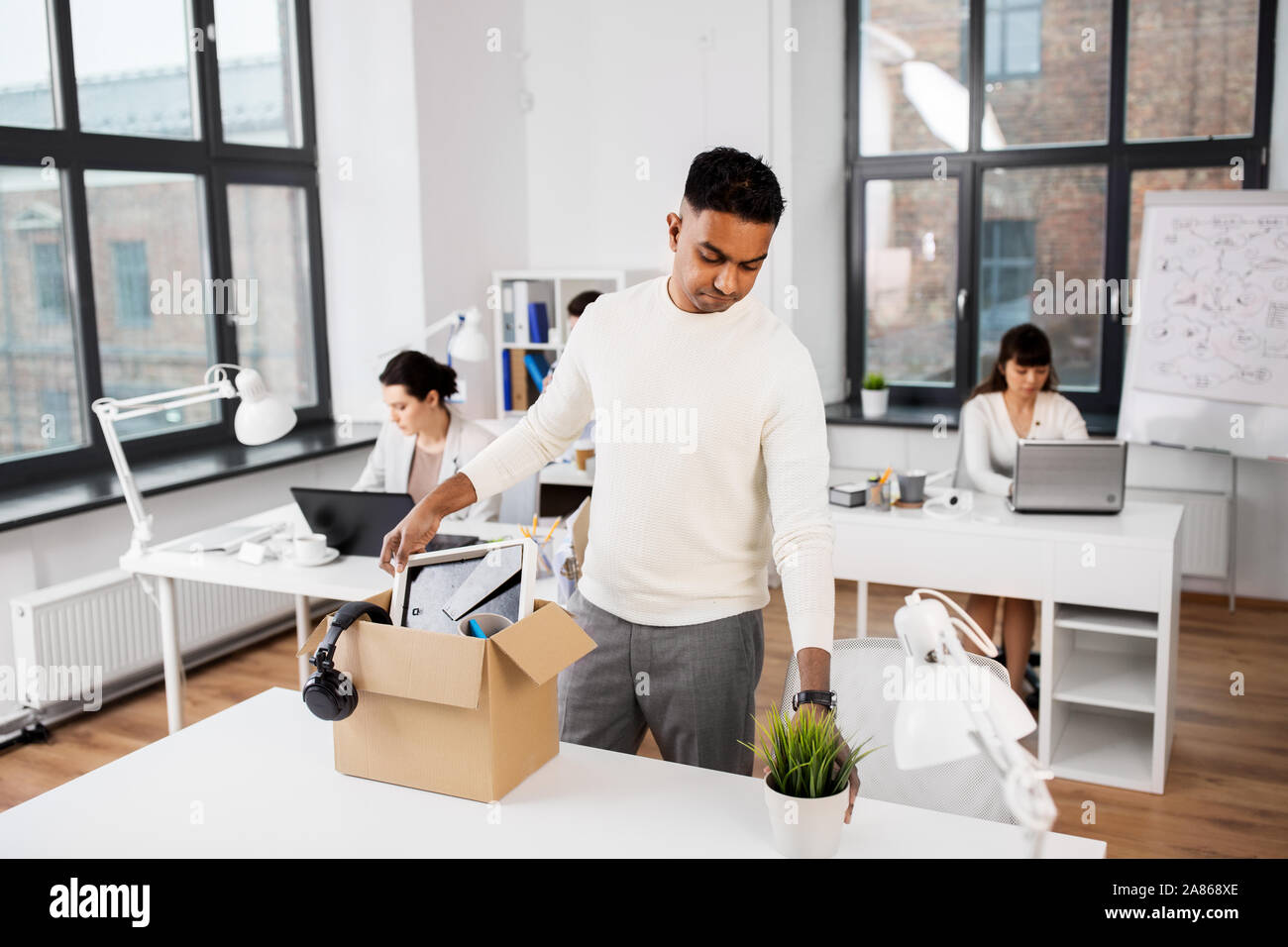 sad fired office worker packing personal stuff Stock Photo - Alamy