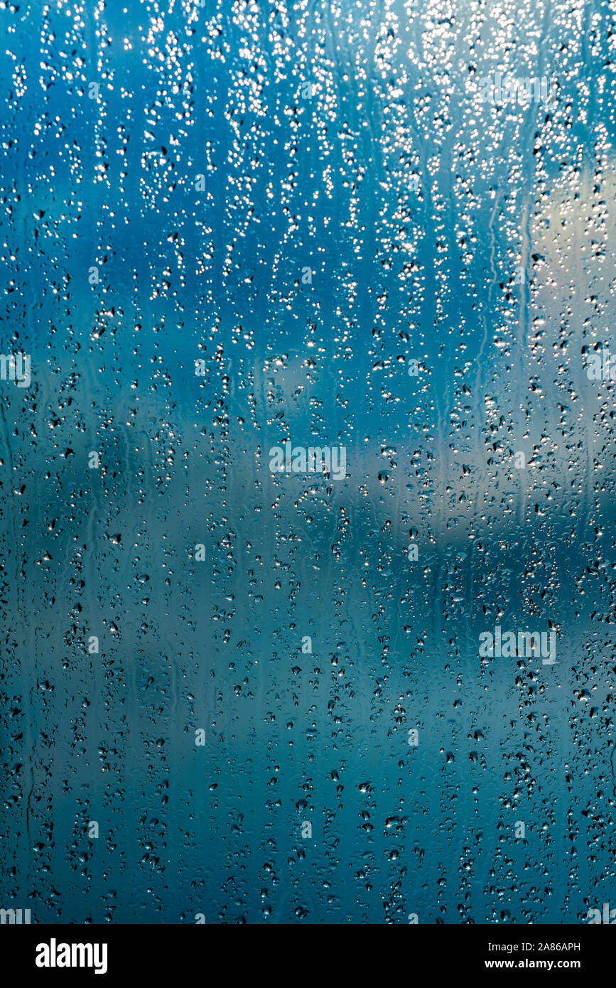 rain drops on window blue background Stock Photo - Alamy