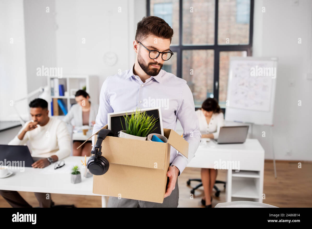 sad fired male office worker with personal stuff Stock Photo - Alamy