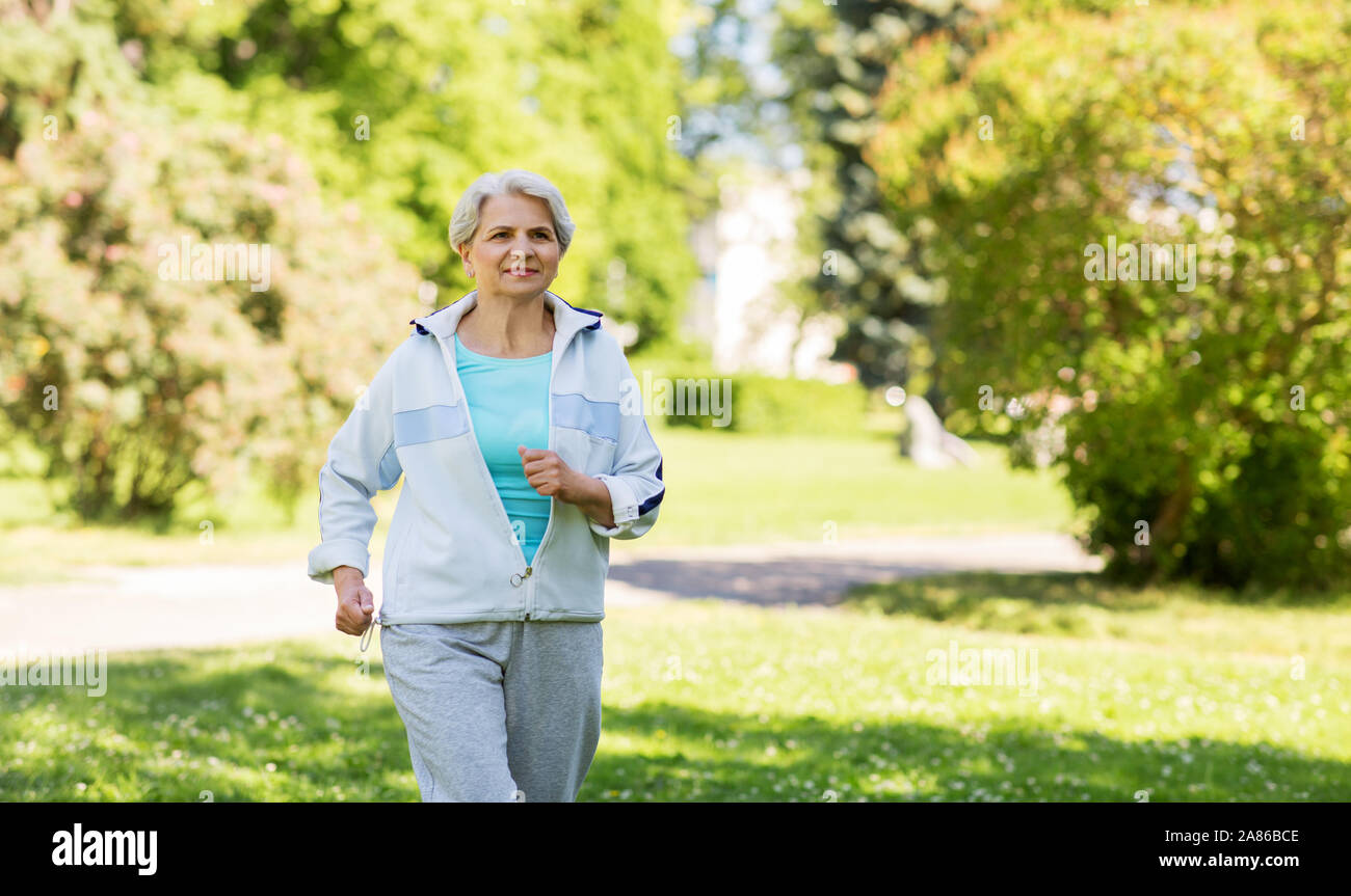 Woman mature running outdoors park hi-res stock photography and images ...