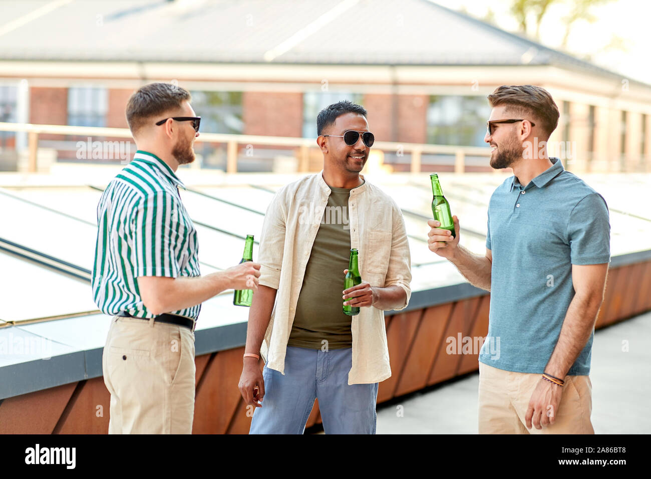 happy male friends drinking beer at rooftop party Stock Photo - Alamy