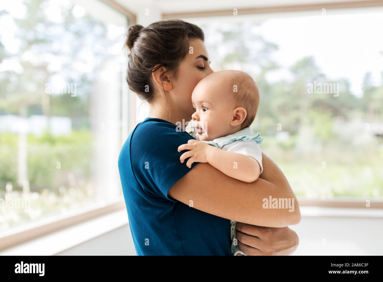 mother holding baby daughter at home Stock Photo - Alamy