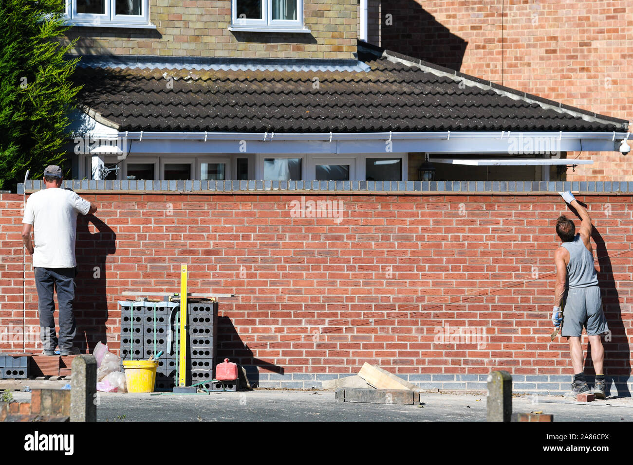 two builders building a wall Stock Photo - Alamy