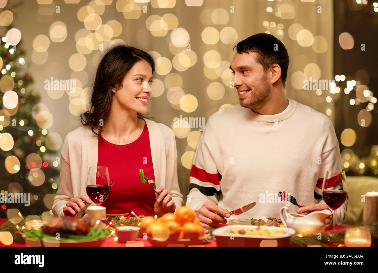 happy couple eating at christmas dinner Stock Photo - Alamy