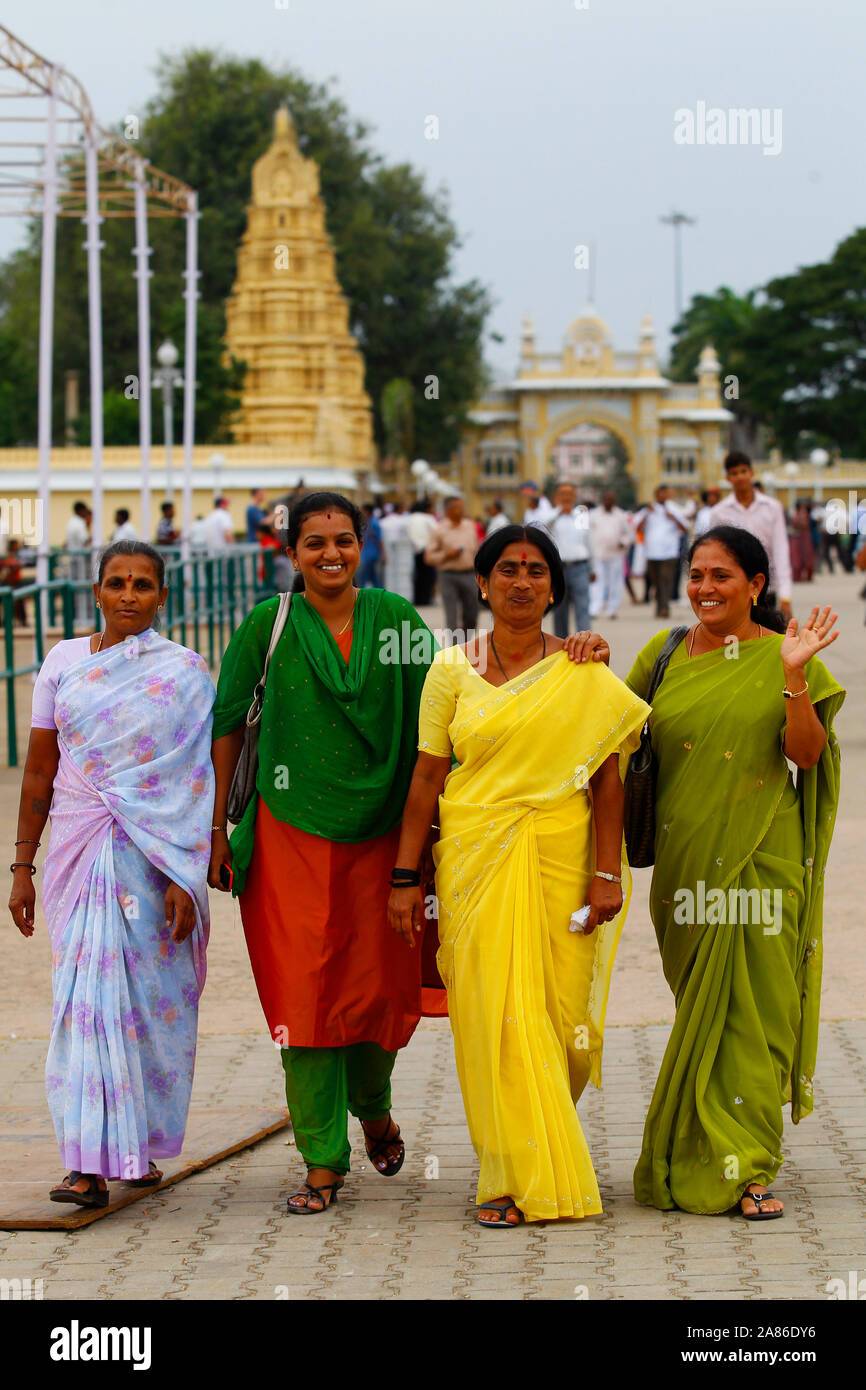 Indian woman in traditional colorful saris visiting the Mysore Palace ...