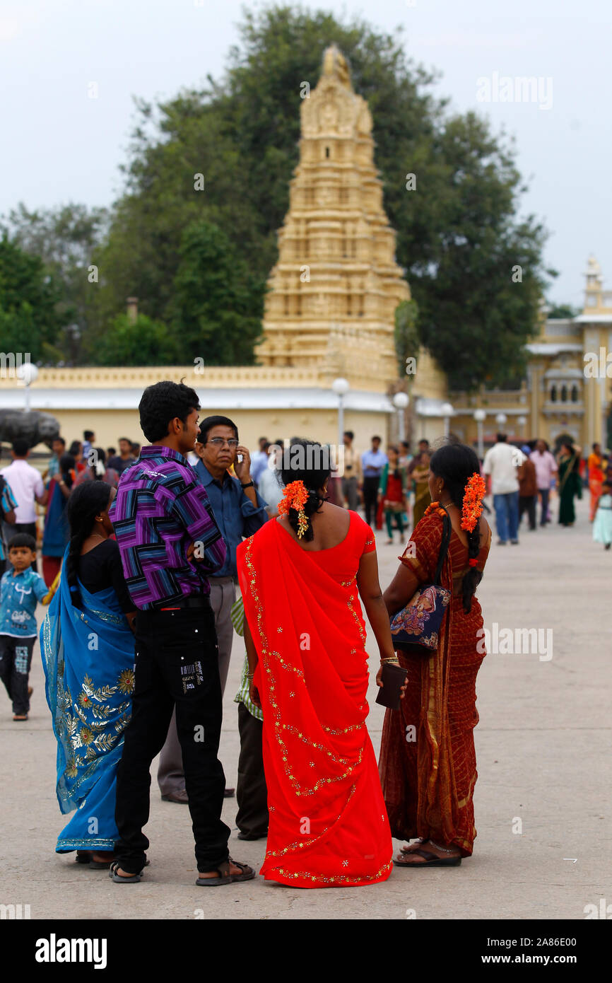 Indian woman in traditional colorful saris visiting the Mysore Palace ...