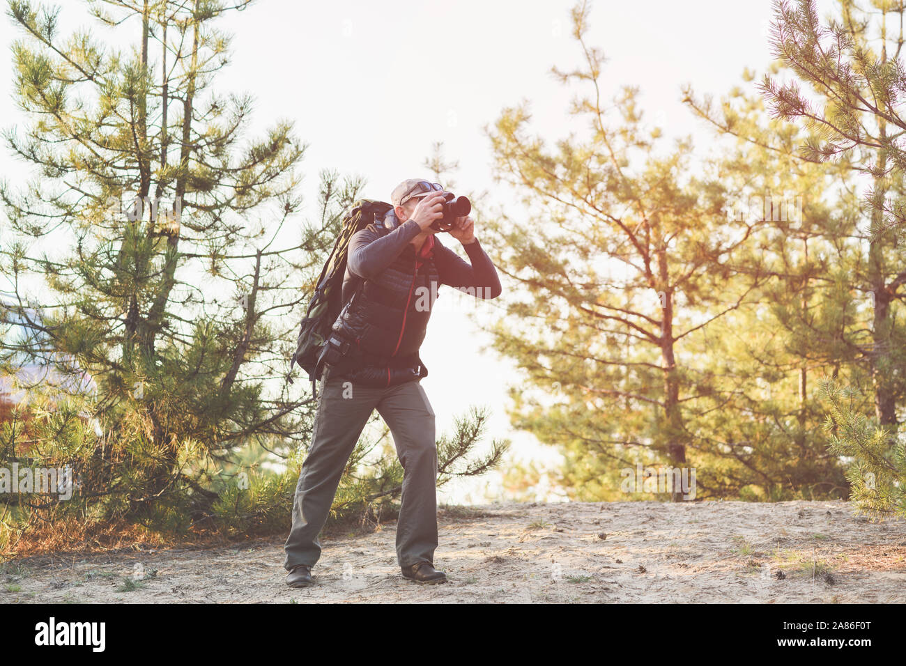 Male photographer with long wide lens camera work at nature, make shots ...